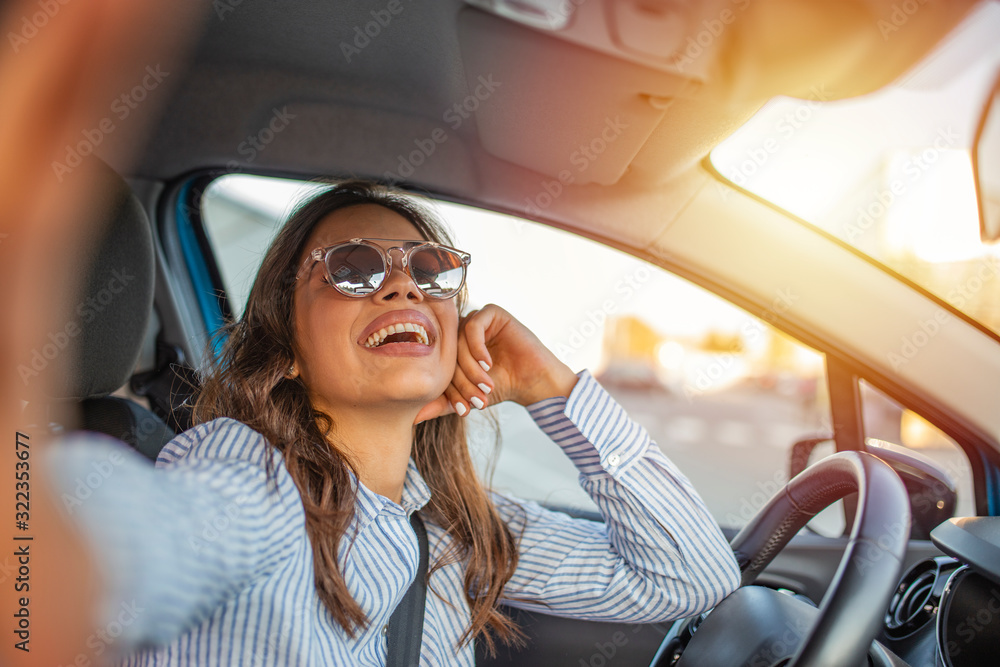 Young smiling womanwith sunglasses making self portrait sitting in the ...