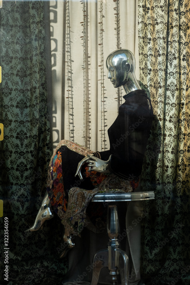 Modern statue of woman sitting surrounded of textile. Fabric material ...