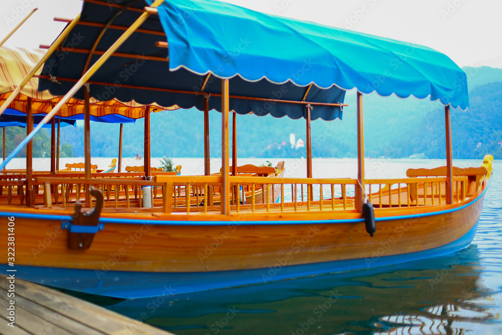 Large wooden rowing gondola boats carrying tourists to Bled lake island ...