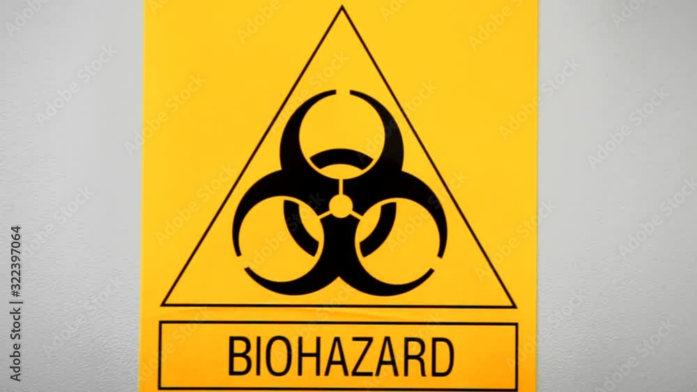 Biohazard sign on laboratory wall. Caution sign for authorised ...