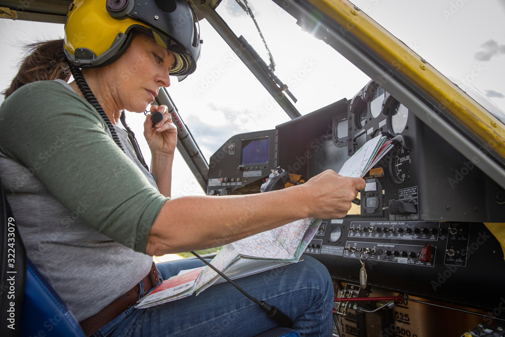 Female pilot checking map inside crop sprayer cockpit Stock Photo ...