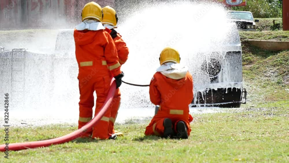Firefighter fighting with fire flame protection property. Fireman wear ...