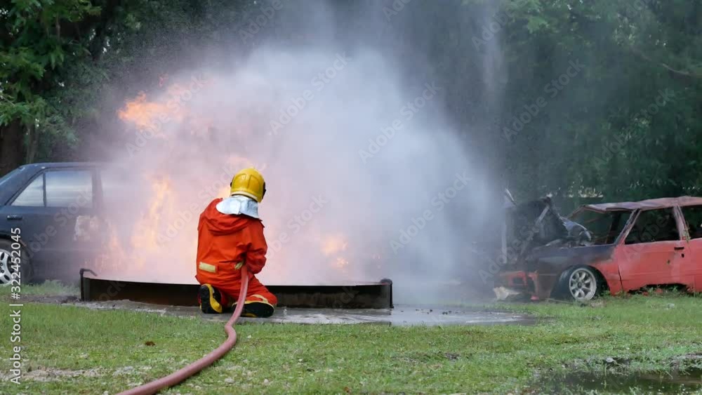Firefighter fighting with fire flame protection property. Fireman wear ...