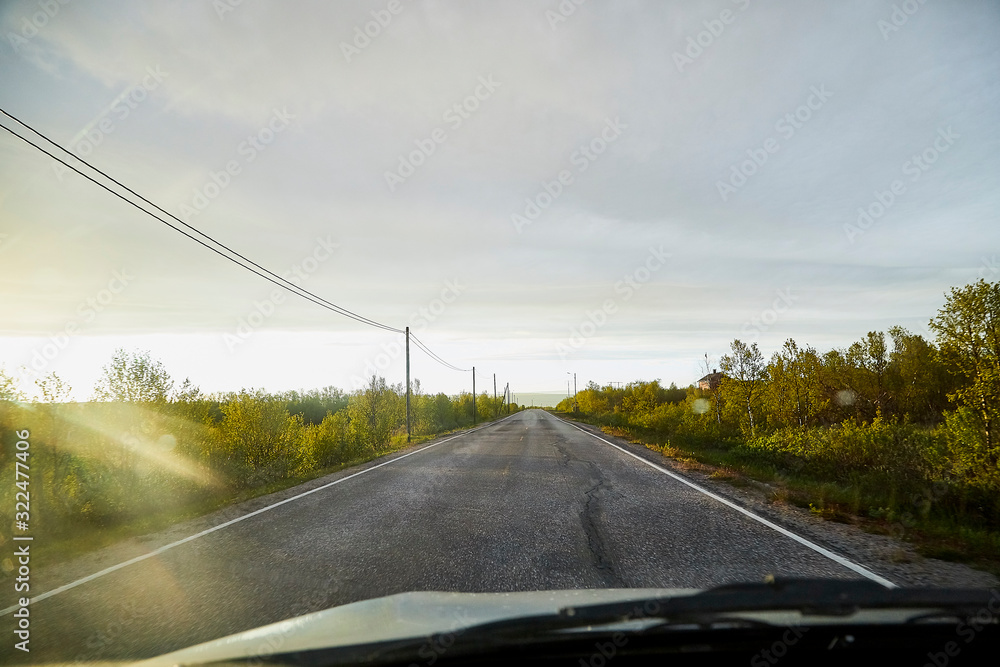 View on yellow sunset and clouds from the car front window and the ...