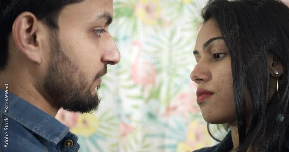 Confident Indian woman catching a smug smiling man by his neck and ...