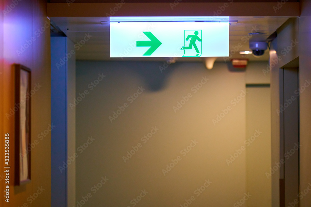 Fire exit sign in the hotel corridor. Stock Photo | Adobe Stock