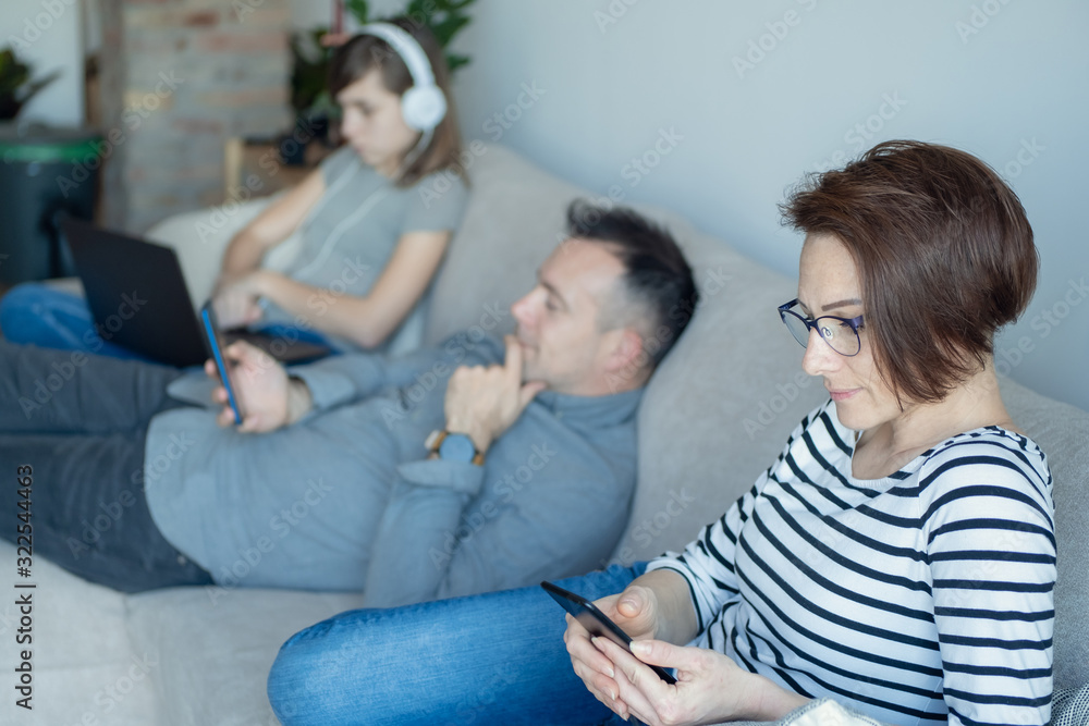 Foto de Technology addicted family: parents and child use laptop and ...