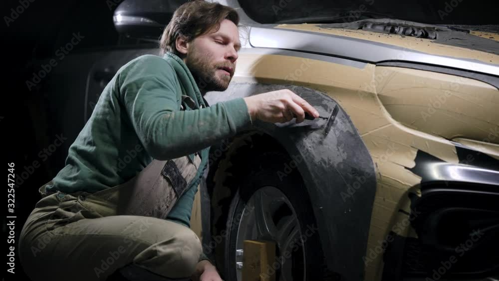 The man works in a tuning studio. Car tuning. The building of the car's ...