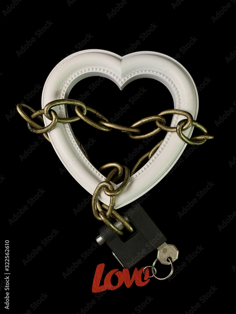 Heart shape locked by a lock on a chain, black background. The white ...