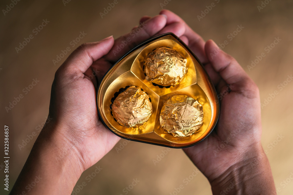 Hand Giving Chocolates Wallpaper. Woman or female hand holding or ...