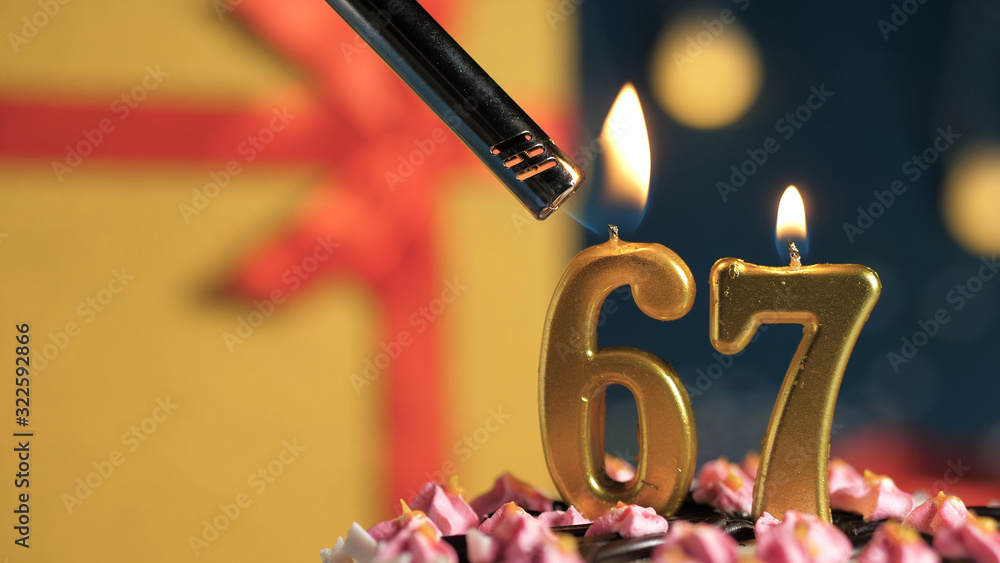 Birthday cake number 67 golden candles burning by lighter, background ...
