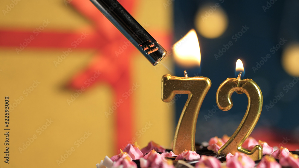 Birthday cake number 72 golden candles burning by lighter, background ...