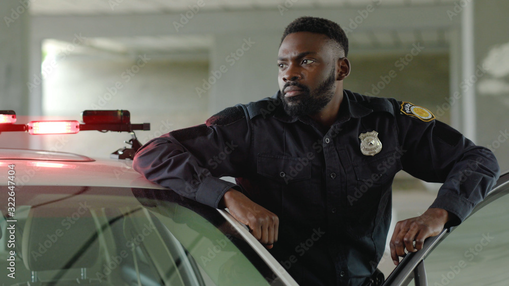 Portrait african american young man cops stand near patrol car look at ...