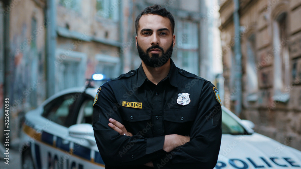 Foto de Close up serious young man cops hold pistol stand near patrol ...