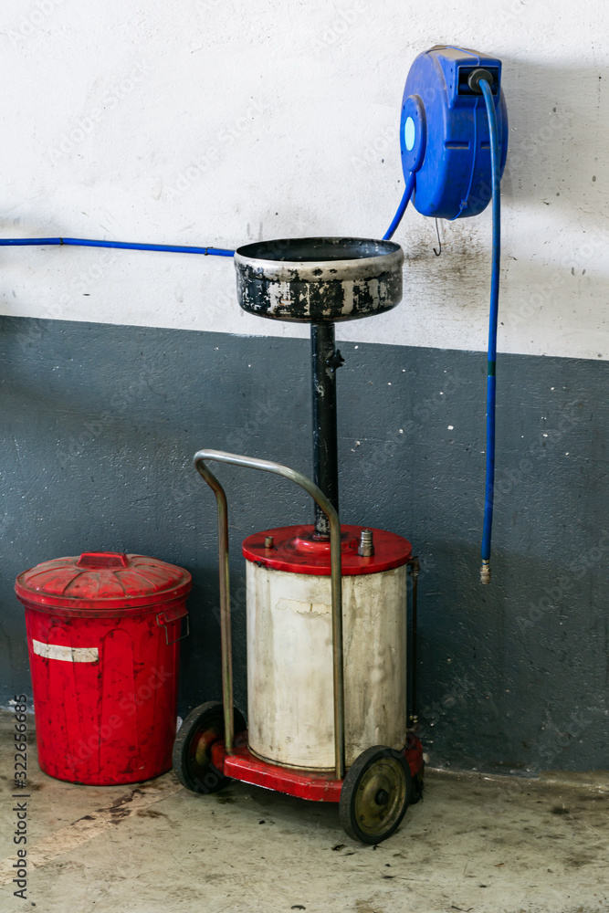 Tank for collecting used oil from the car next to a pressurized air ...