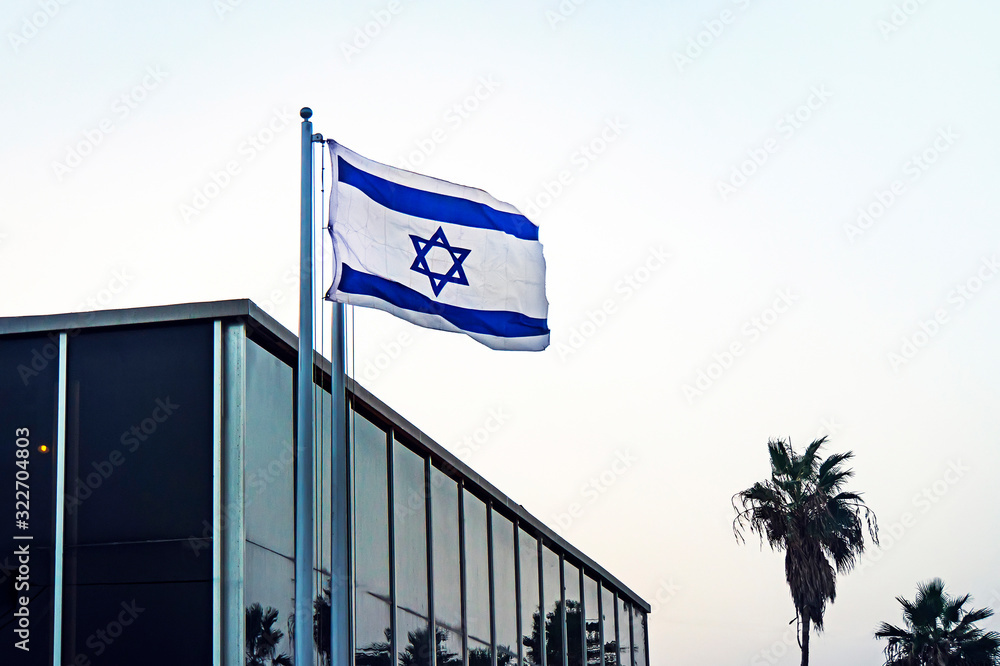 flag of Israel flutters in the wind against the background of the ...