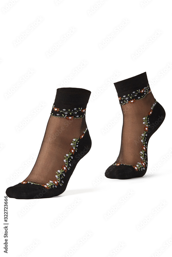 Cropped Shot Of Female Feet On Tiptoe In Black Nylon Sheer Socks With Embroidered Colorful