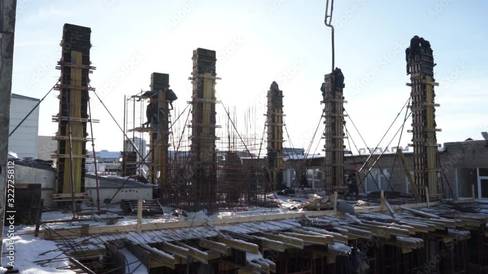 the process of pouring concrete with a hose, columns and floors of a ...