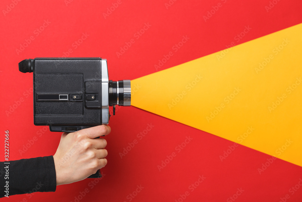 Female hand holding old style film movie camera imitating shooting ...