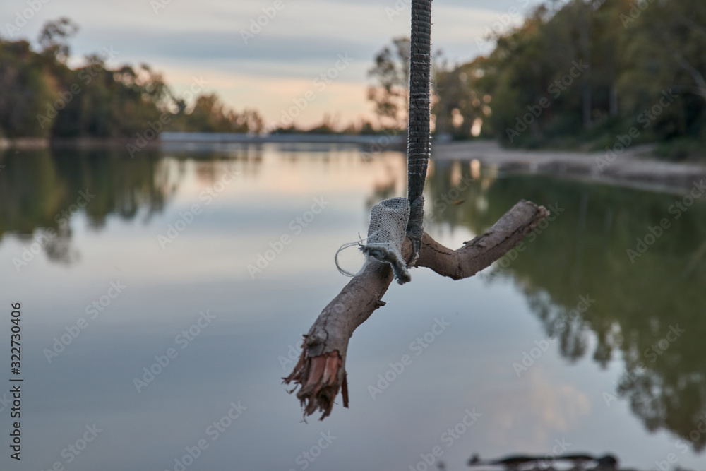 Rope swing in a lake at the sunset with bur background with sky ...