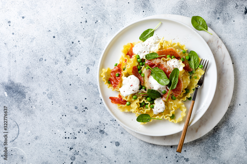 Italian pasta mafalde with green peas, prosciutto, burrata, and spinach ...