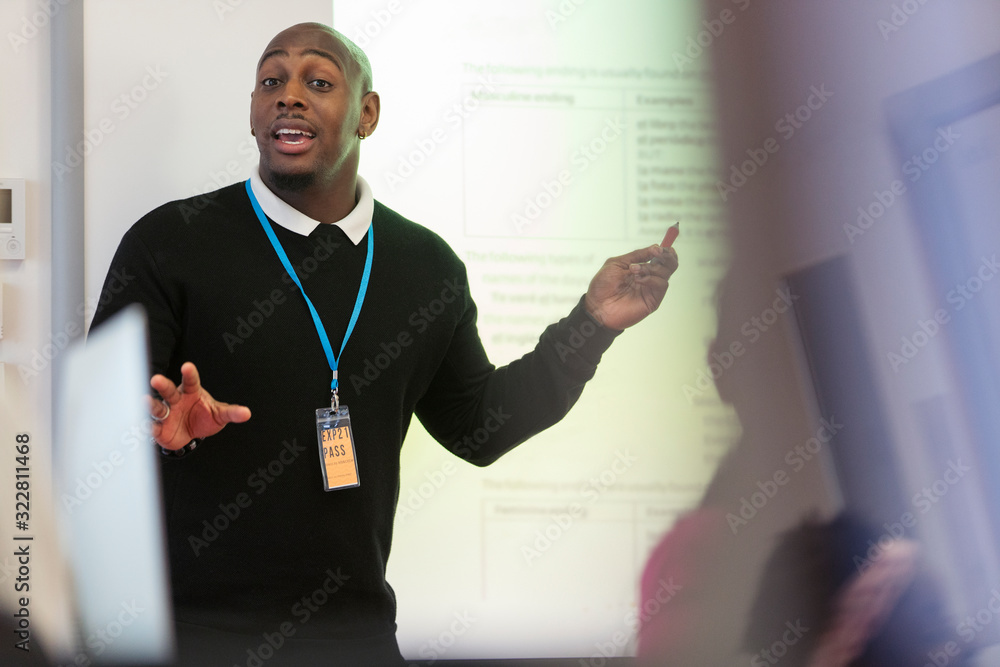 Male instructor leading lesson at projection screen in classroom Stock ...