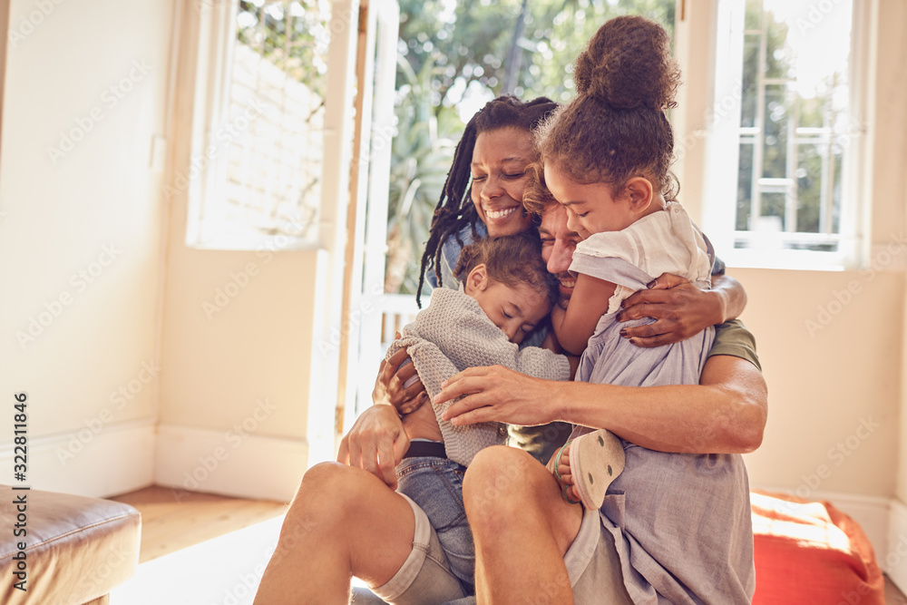 Happy affectionate young family hugging Stock Photo | Adobe Stock