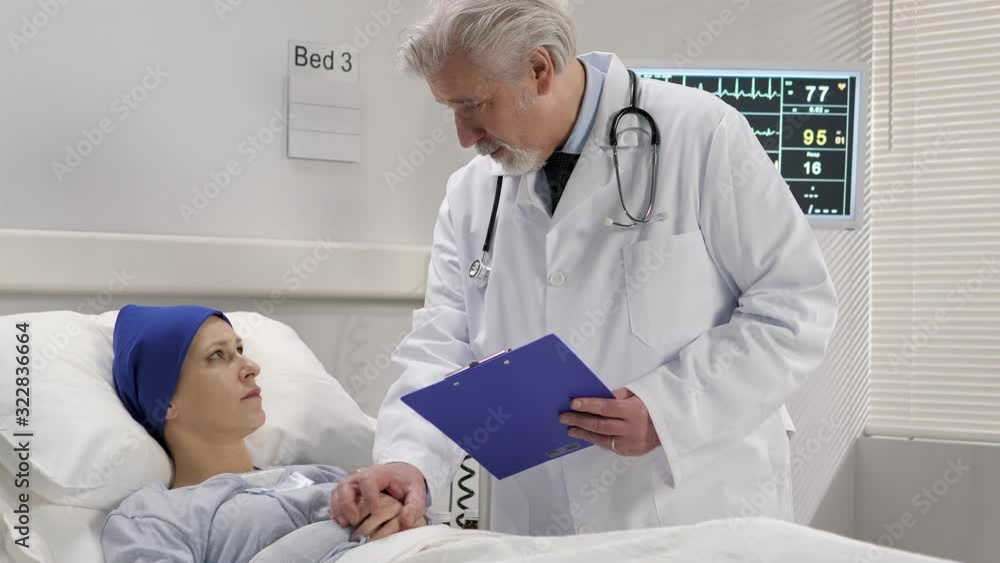 doctor talking with a patient suffering from cancer lying in a hospital ...