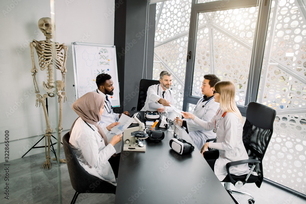 Multi ethnic group of medical students or young reseachers having a ...