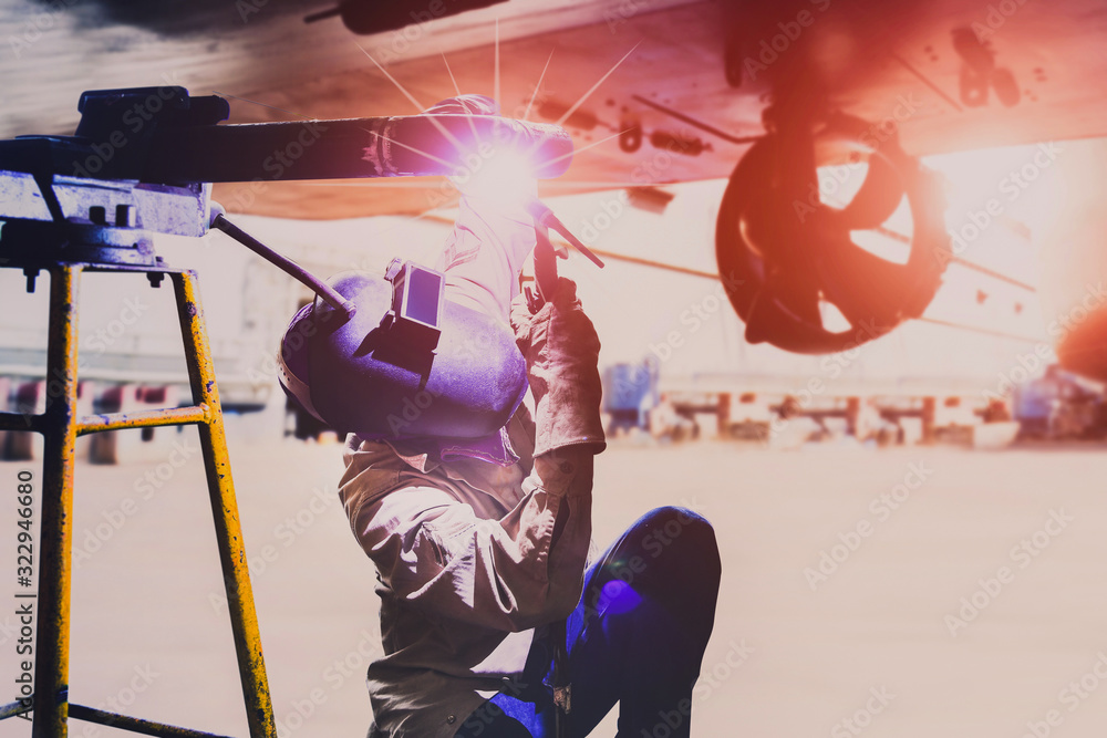 Welder is welding ship hull in shipyard maintenance and ship repair ...