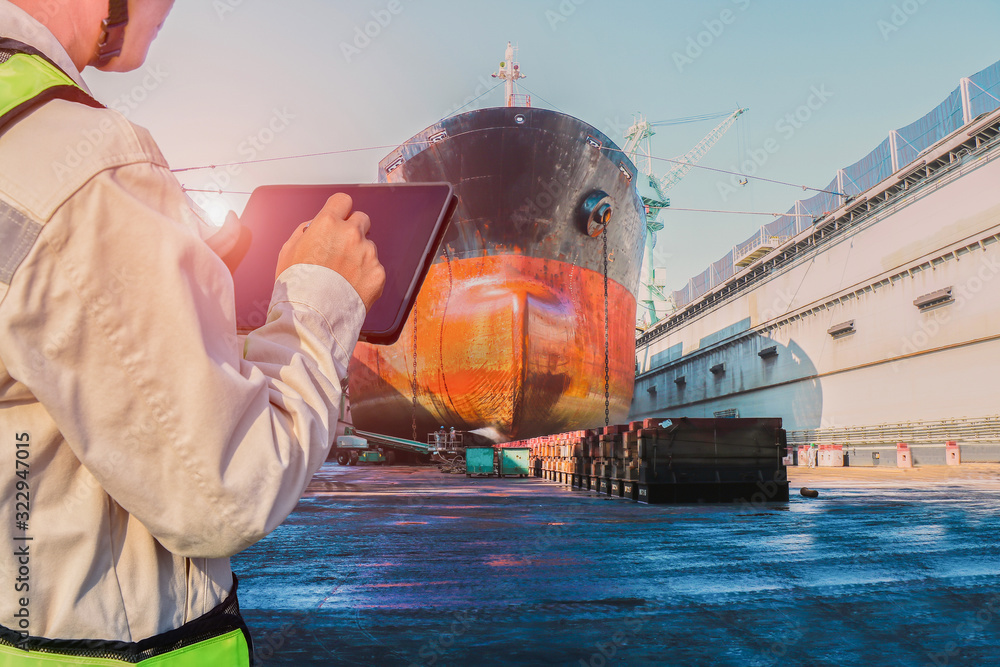 surveyor inspection ship repair from tablet, Cargo ship moored in ...