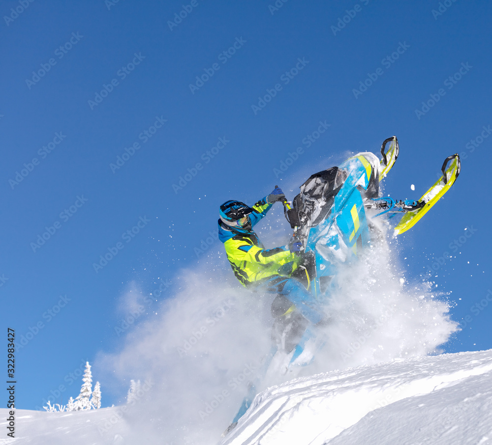 elite sports snowmobiler rides and jumps on steep mountain slope with ...