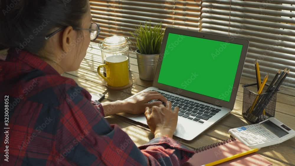 Over the shoulder shot of a business woman working looking at green ...