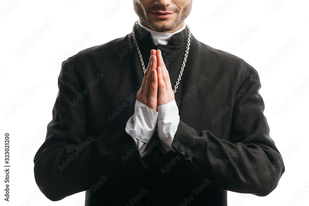 cropped view of catholic priest in black cassock praying isolated on ...