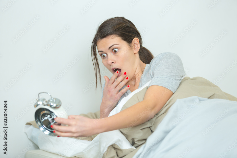 woman overslept and shocked with the alarm Stock Photo | Adobe Stock