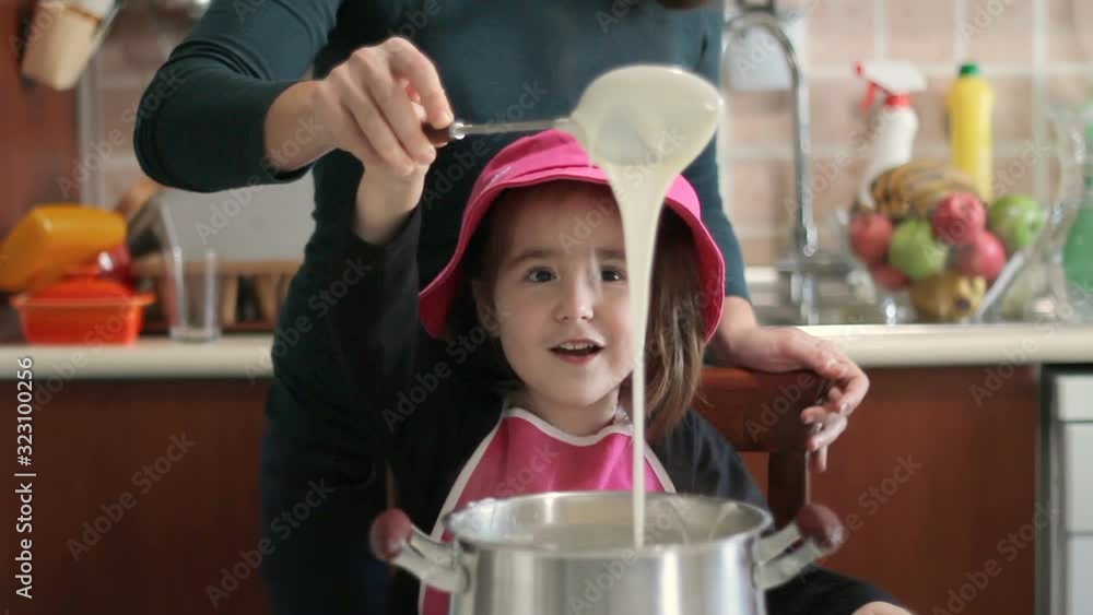 Little girl chef in the kitchen. Girl child making cake cream in the ...
