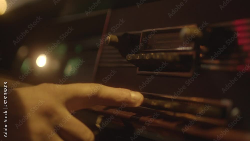 Close-up of man's hand turning on a vintage car radio in retro ...