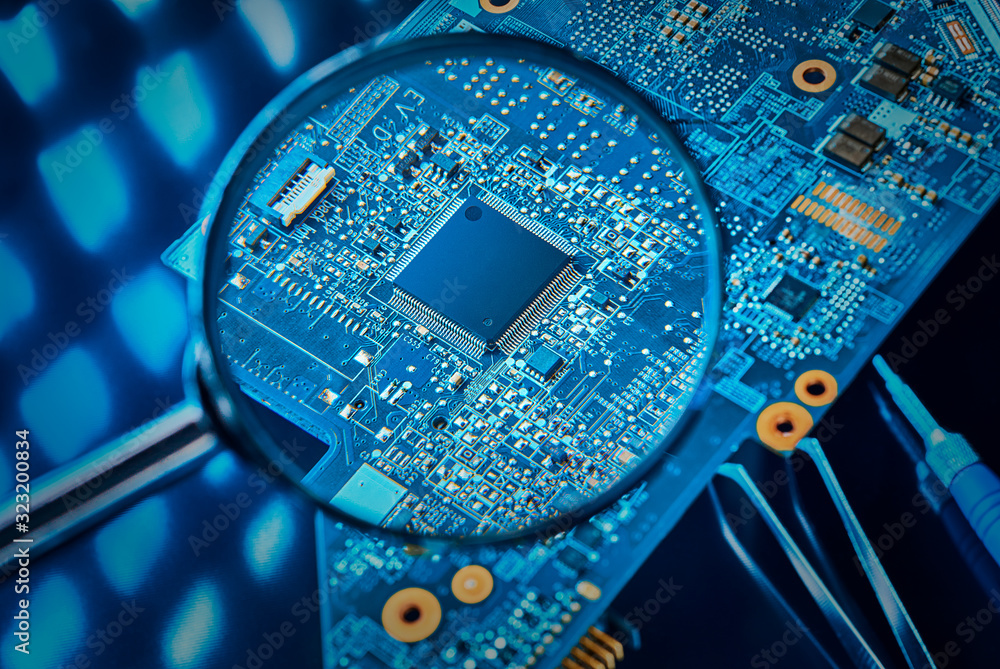 Chip on the computer's motherboard close-up through a magnifying glass ...