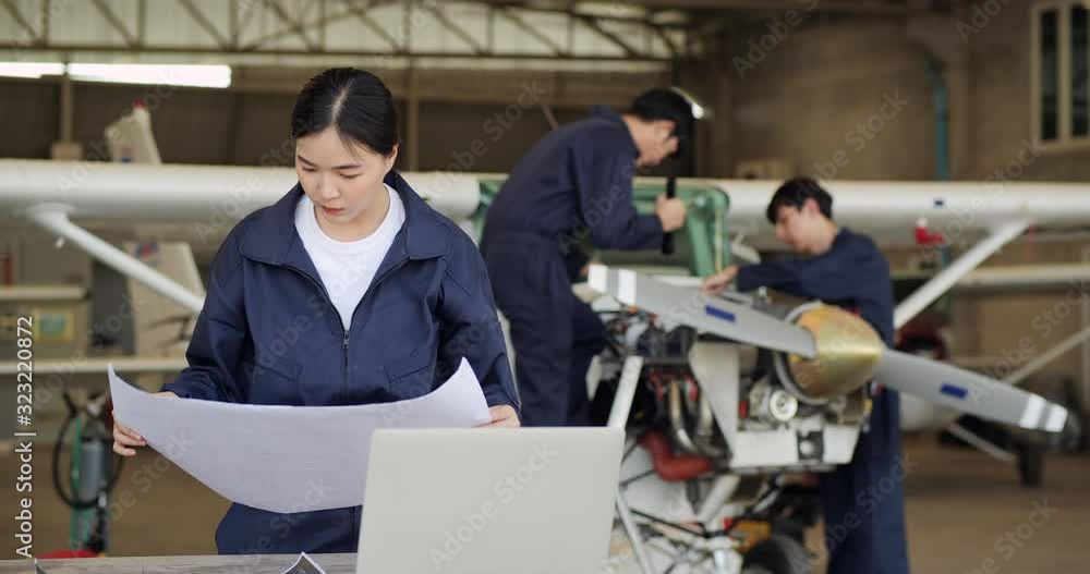 Portrait of Female engineer or pilot looking in airplane hangar to ...