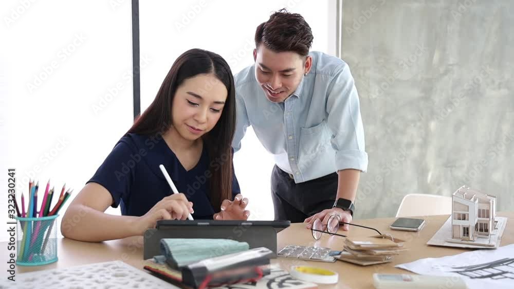 Asian Interior Architect working with architectural model choosing ...