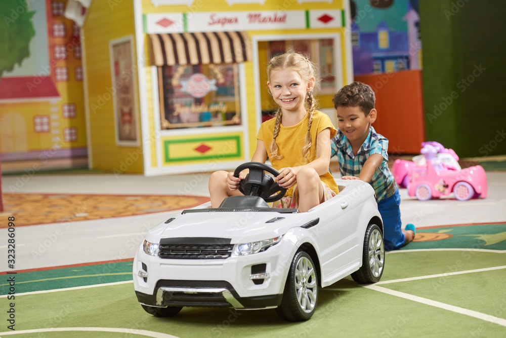 Little boy pushing toy car indoor. Two happy kids playing with big toy ...