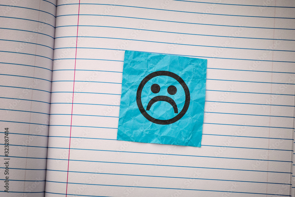 Blue paper note with sad face on a lined paper Stock Photo | Adobe Stock