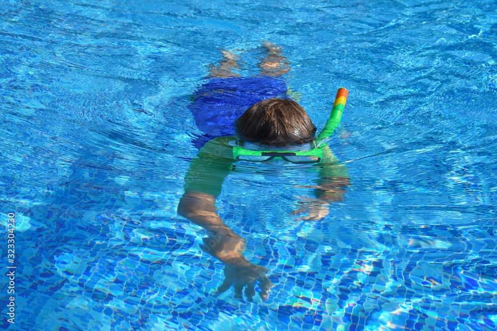 Baby boy in the water mask in the pool. Child swimmer in the water ...