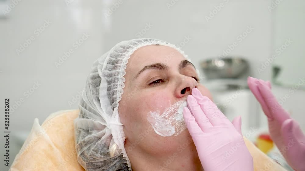 Doctor cosmetologist putting plastic film on cream with anesthesia on ...