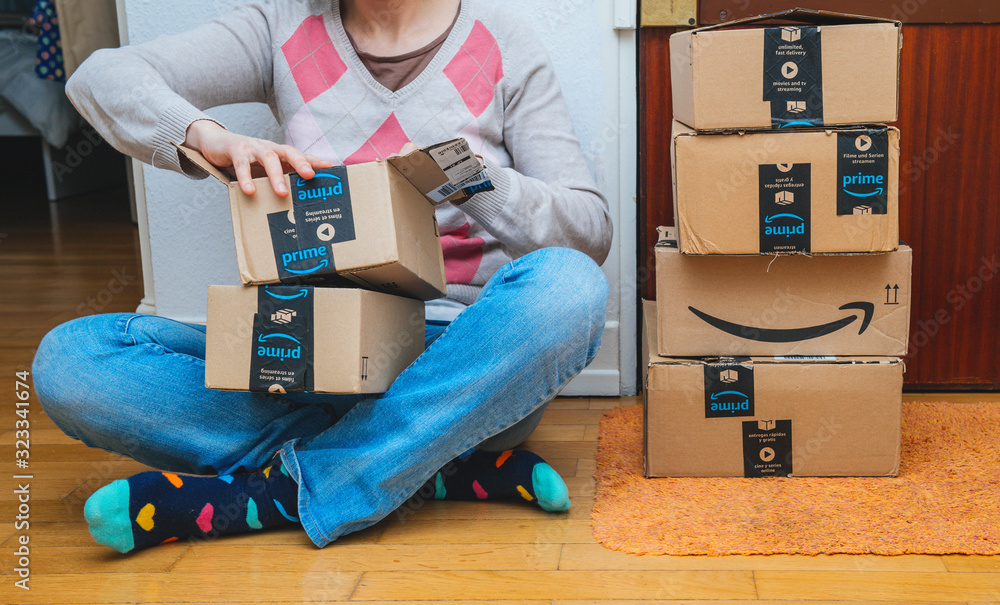 PARIS, FRANCE - JAN 13, 2018: Woman next to stack of Amazon Prime ...