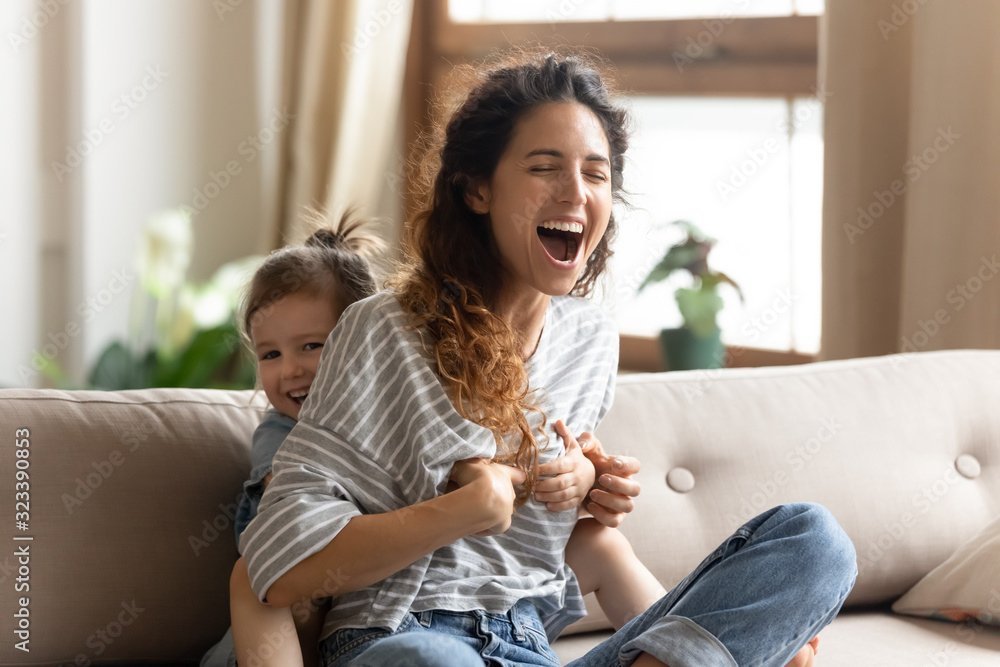 Playful little child girl tickling laughing woman. Stock Photo | Adobe ...