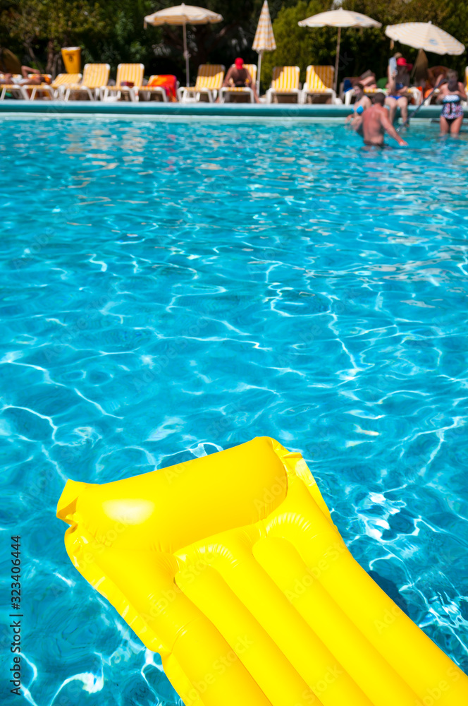Poster Bright yellow lilo floating in the sun on a rippling blue ...