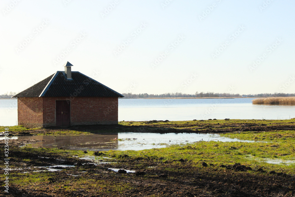 The flooded brick house stands at the coast. A boathouse built of red ...