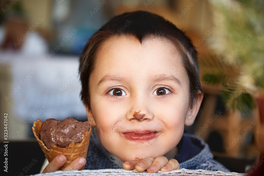 Funny four years caucasian little boy with face stained a chocolate ...