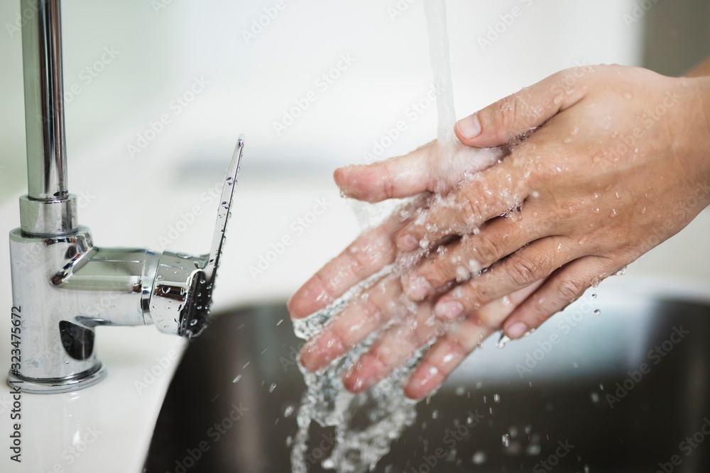 washing hands in sink. Stock Photo | Adobe Stock